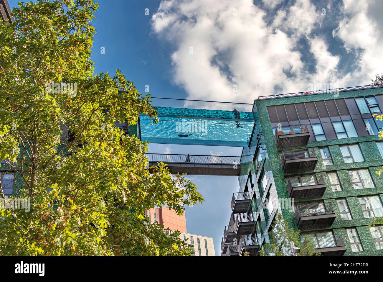 People swimming in The Sky pool, which stretches between two luxury ...