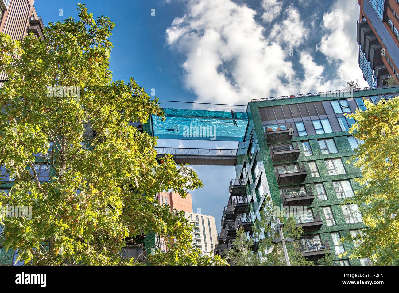 People swimming in The Sky pool, which stretches between two luxury ...