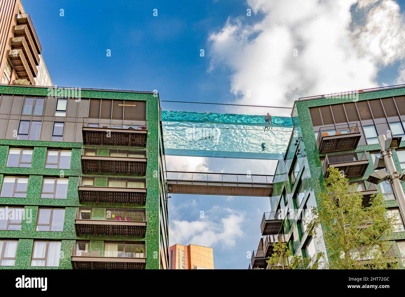 People swimming in The Sky pool, which stretches between two luxury ...