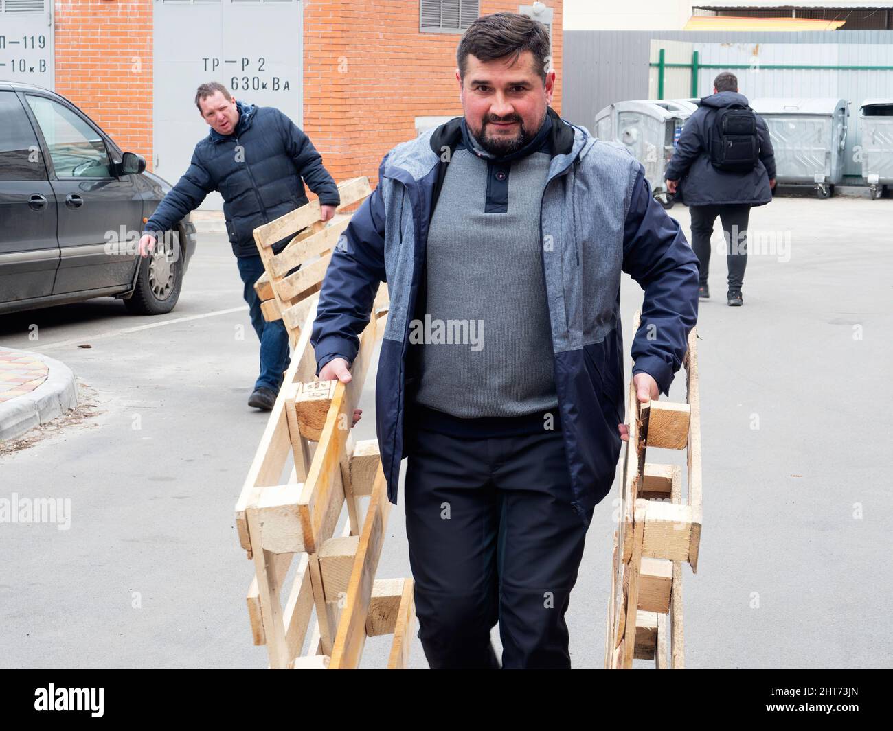 Residents of an apartment building carry pallets to the basement to ...