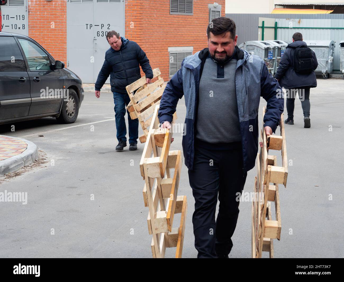 Residents of an apartment building carry pallets to the basement to ...