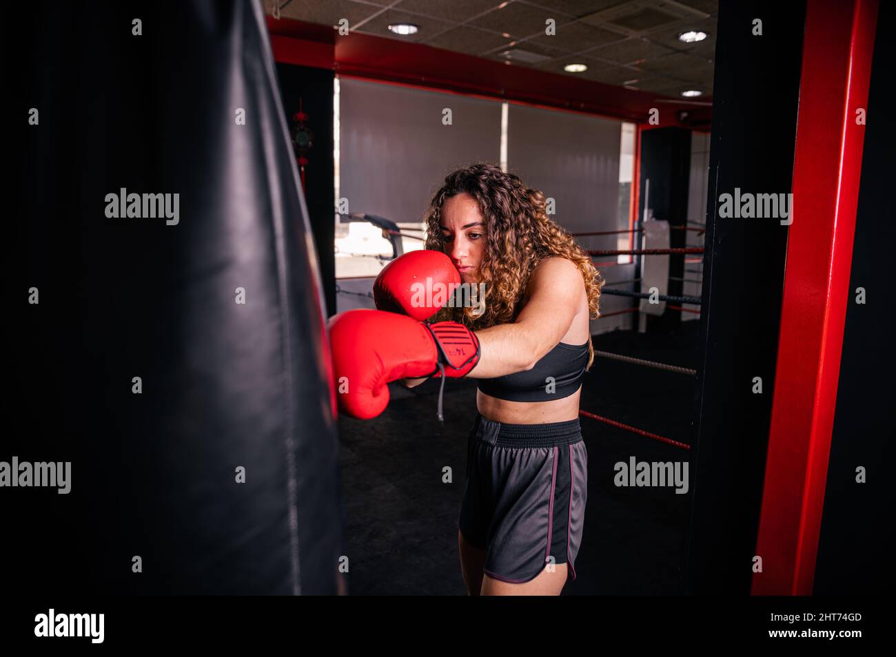 Curly brunette Caucasian female practicing boxing in the ring Stock ...