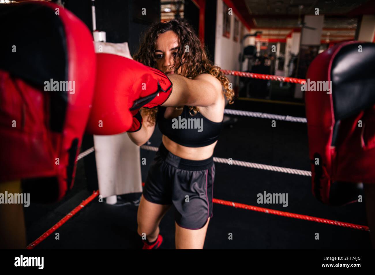 Curly brunette Caucasian female practicing boxing in the ring Stock ...
