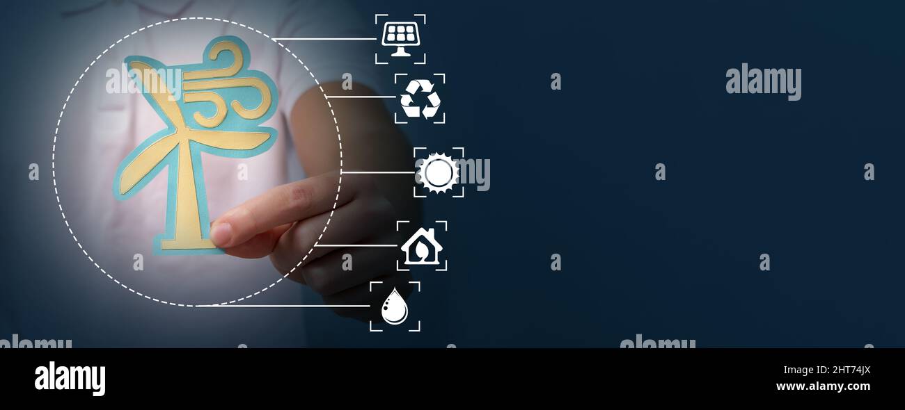 Human hand holding wind turbine icon with renewable energy symbols ...