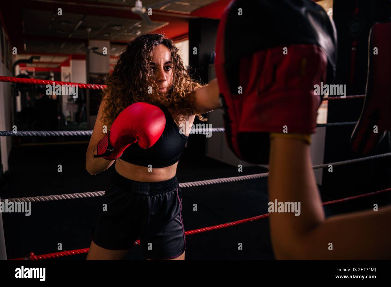 Curly brunette Caucasian female practicing boxing in the ring Stock ...