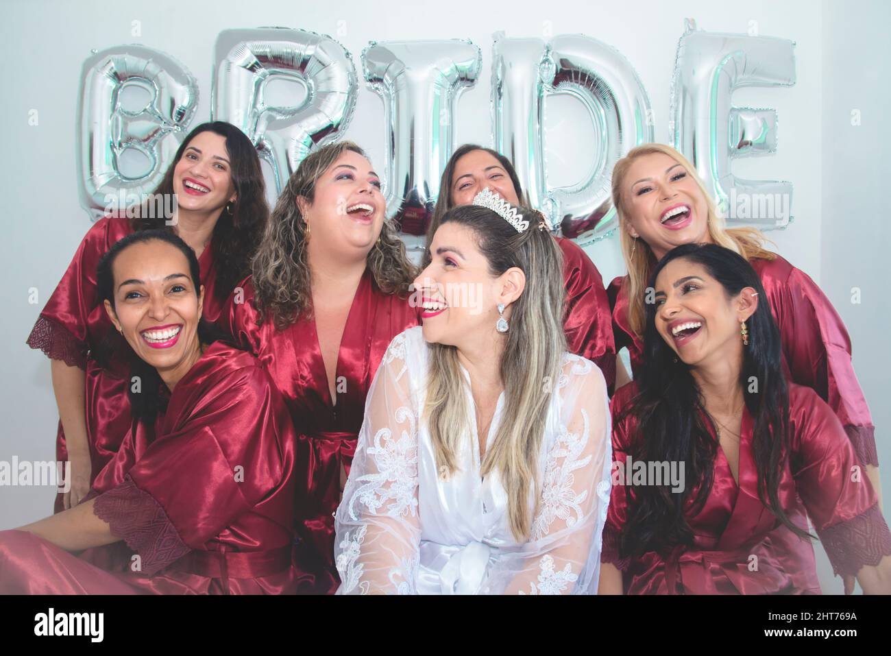 Bride and bridesmaids together in portrait against white background ...
