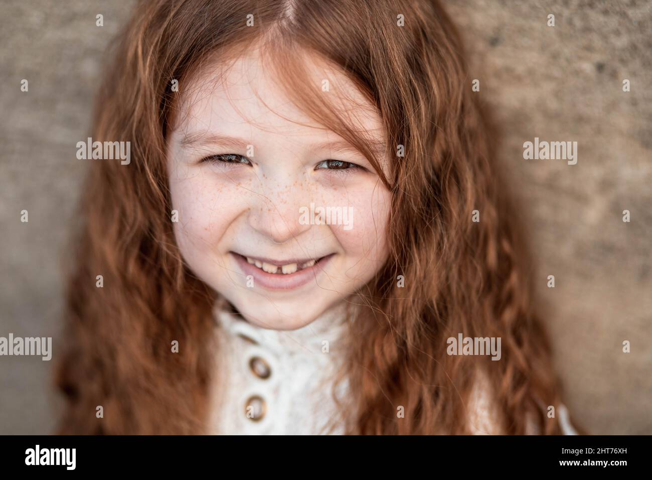 Portrait of a cute, little, freckled, ginger girl in shirt smiling ...