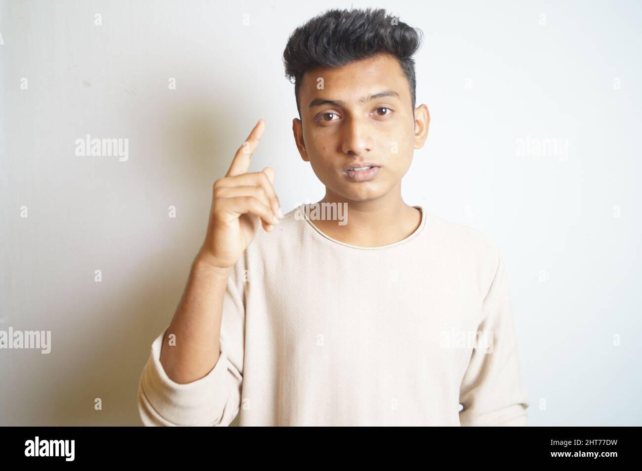 An Indian man pointing up on a white background Stock Photo - Alamy