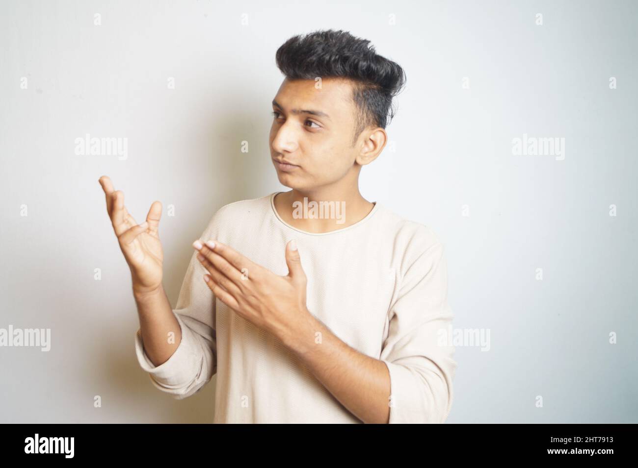 Indian man pointing at something on a white background Stock Photo - Alamy
