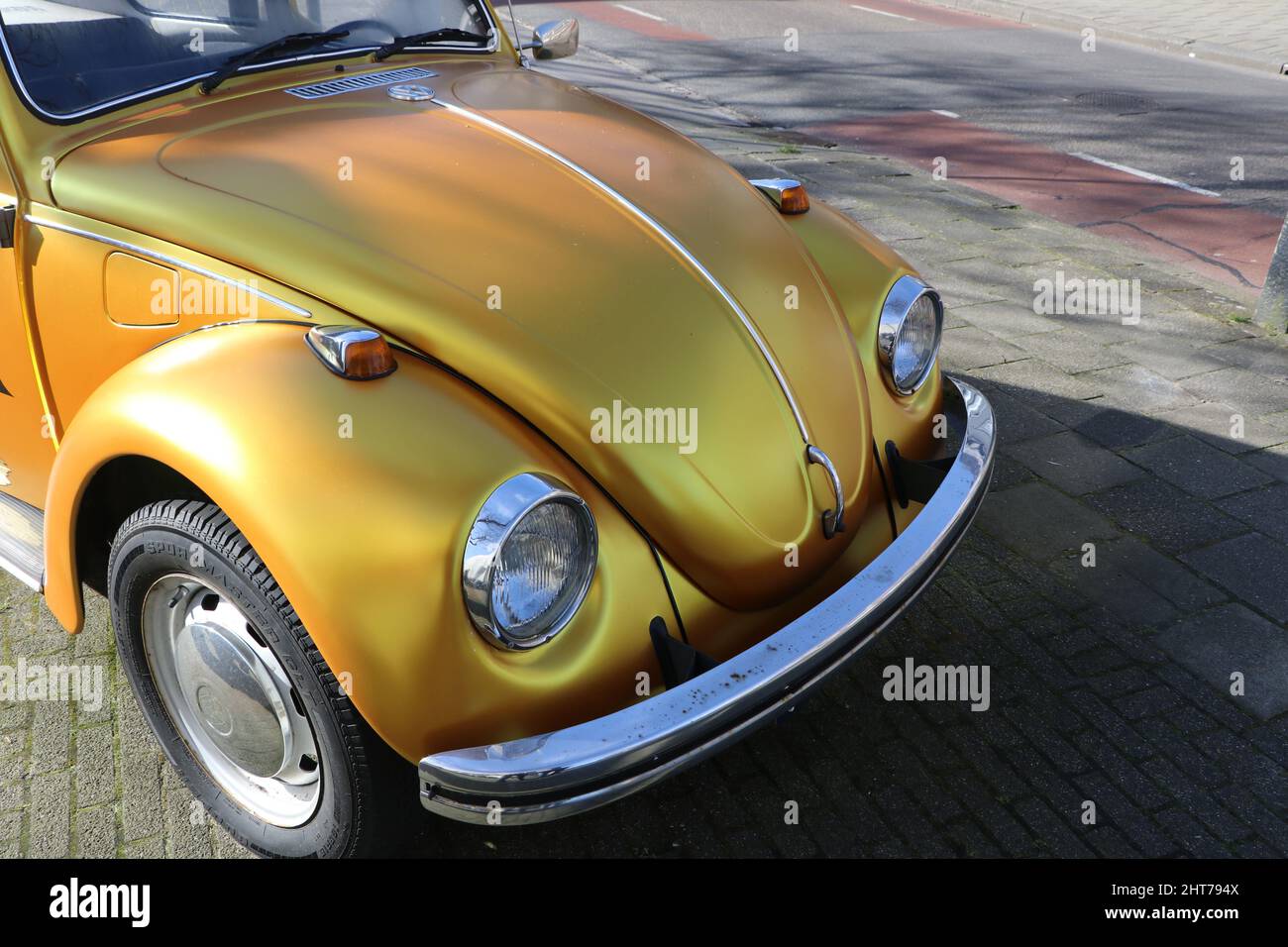 front of gold colored vintage Volkswagen beetle car on street in the ...