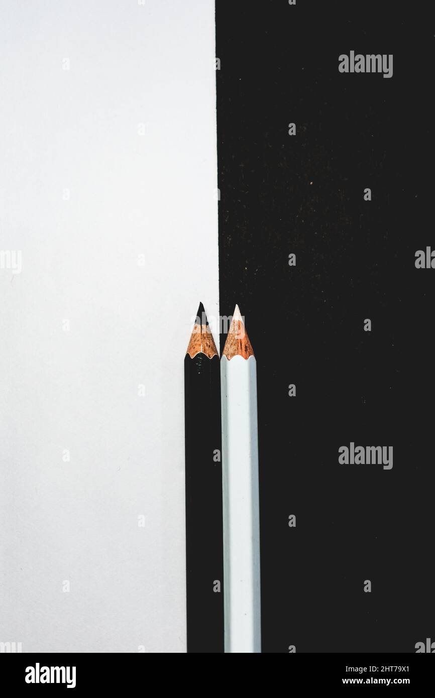 Vertical shot of black and white pencils on the background of the ...