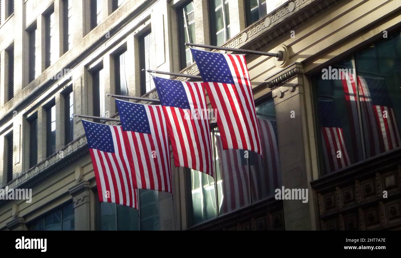 Exterior facade of American flags hanging from the wall of a building ...