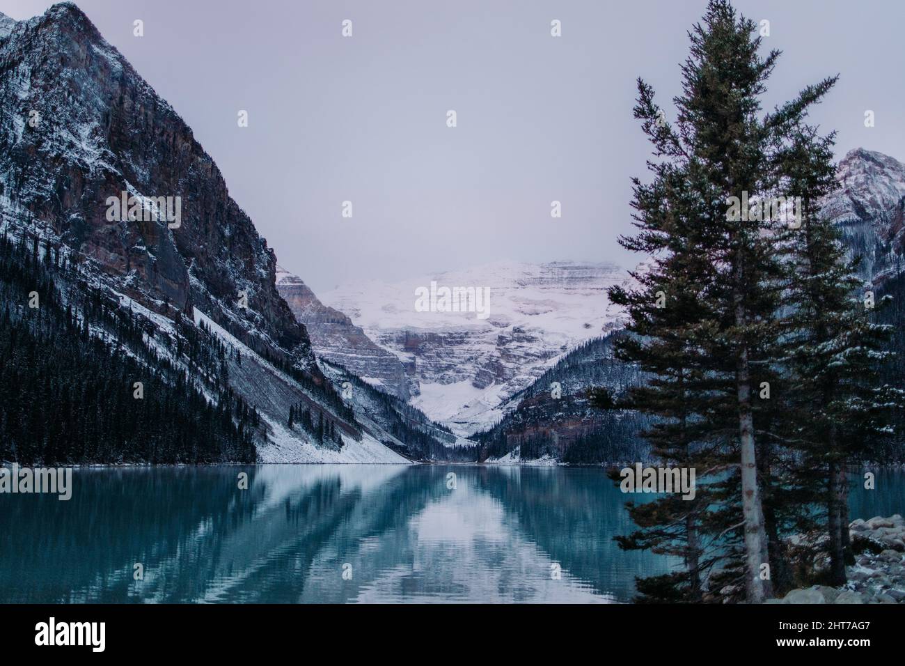 Beautiful shot of snow-covered mountains reflecting in a clear calm ...