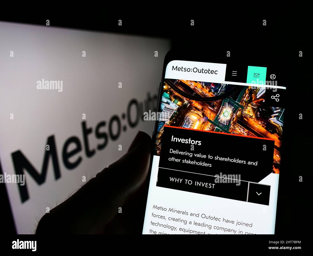 Person holding cellphone with webpage of Finnish machinery company ...