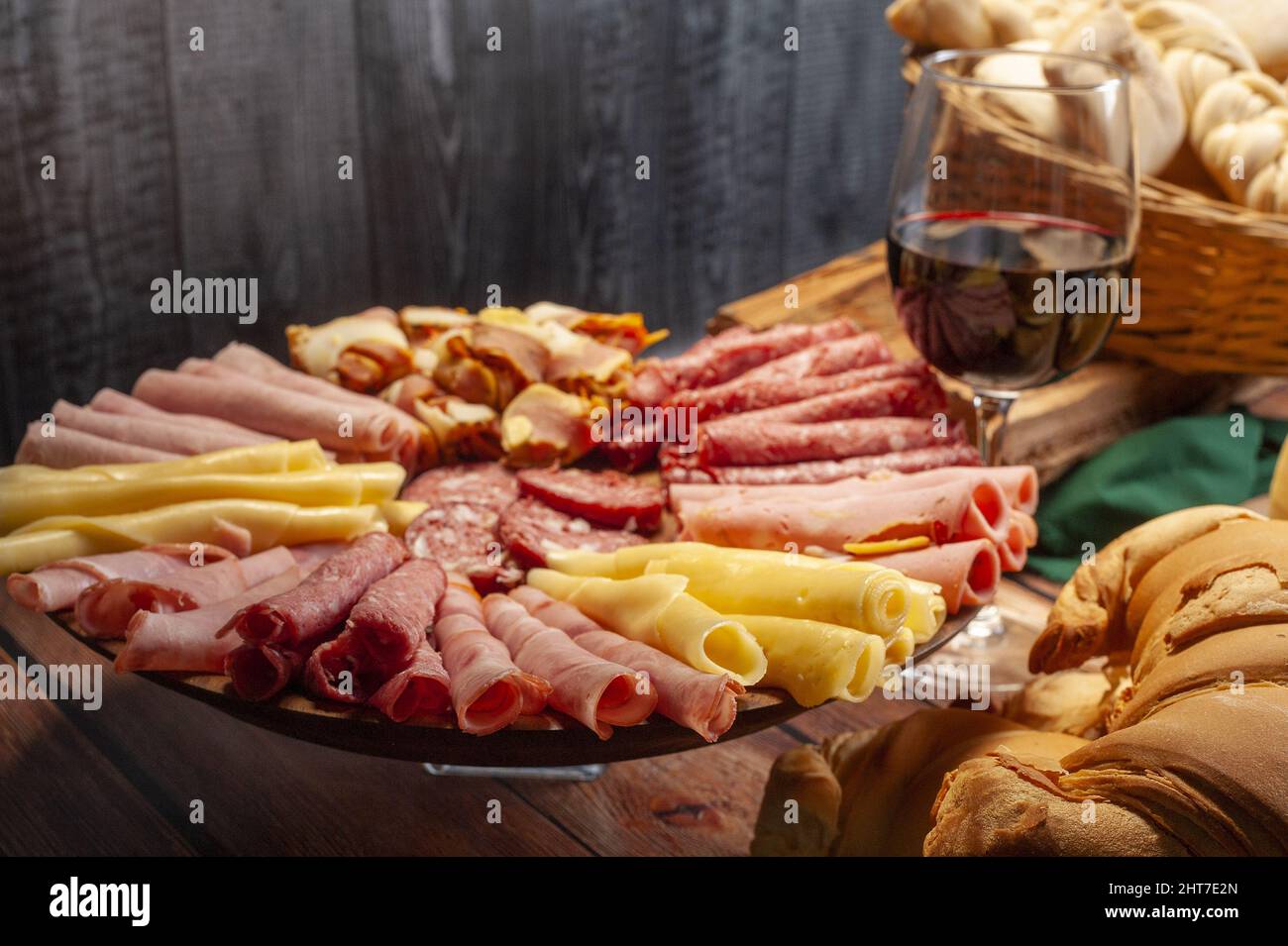 Wooden table with many types of tasty meat and cheese appetizers Stock ...