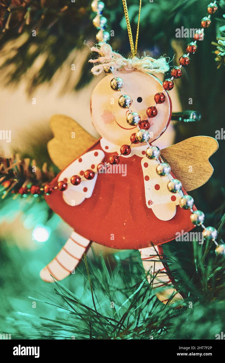 A vertical closeup of a wooden angel ornament hanging from a Christmas ...