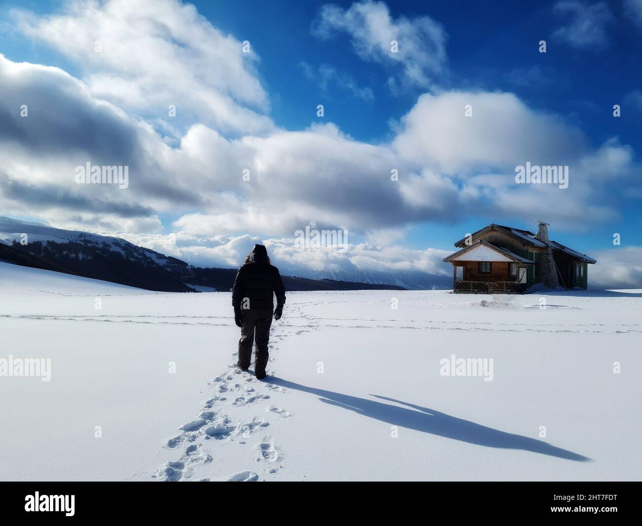 Back view of a man walking towards a mountain hut in Passolanciano ...