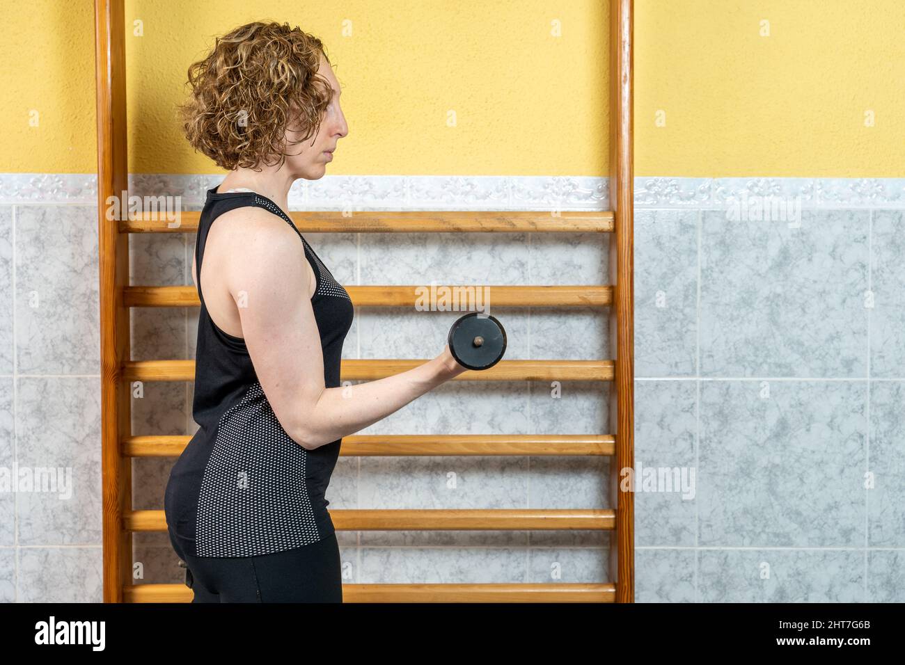 Spanish woman doing dumbbells exercise in a Physical therapy clinic ...