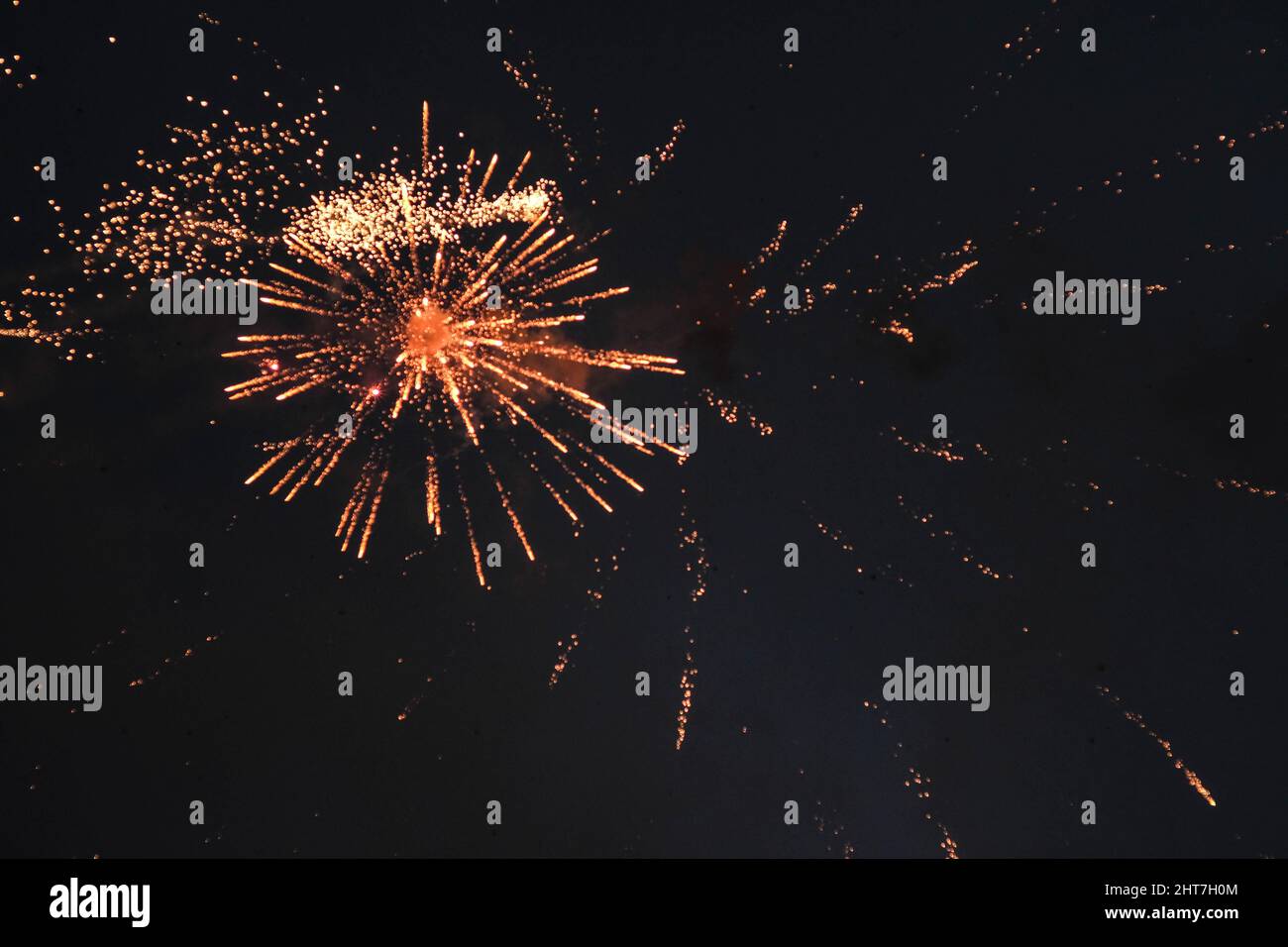Low angle shot of festive fireworks bursting in night sky with orange ...