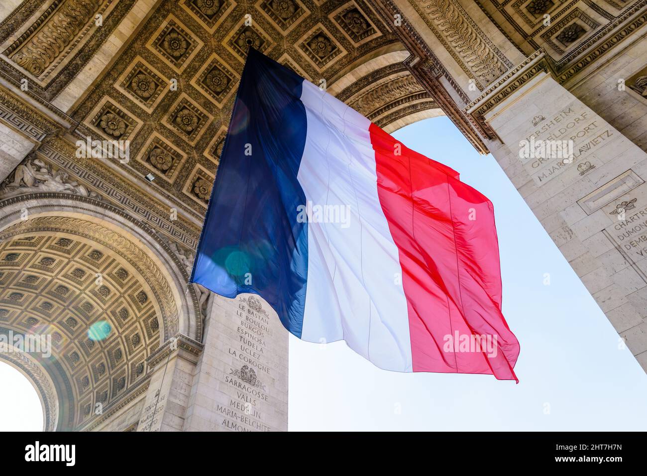 Low angle view of a large french flag fluttering in the wind under the ...