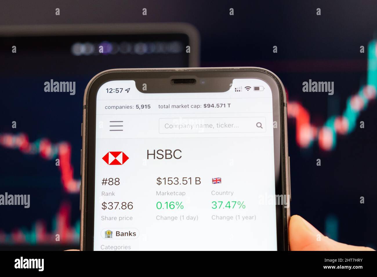 HSBC stock price on the screen of cell phone in mans hand with changing ...