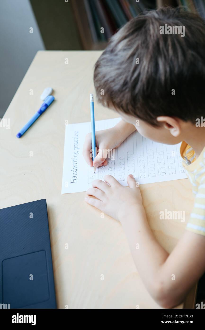 Top view to cute boy doing his homework Stock Photo - Alamy