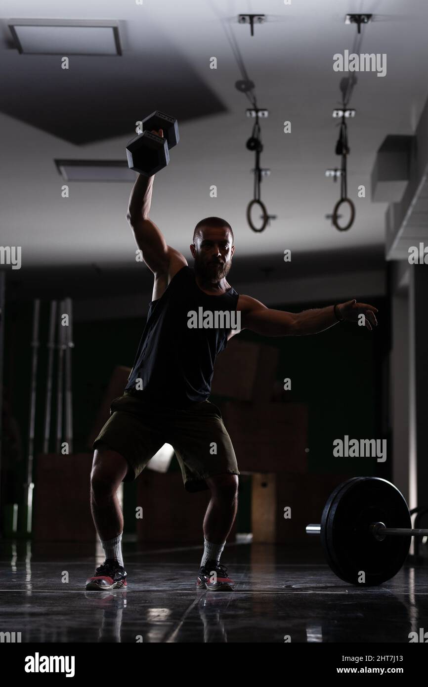 Silhouette of a muscular athlete lifting very heavy weights. Man ...