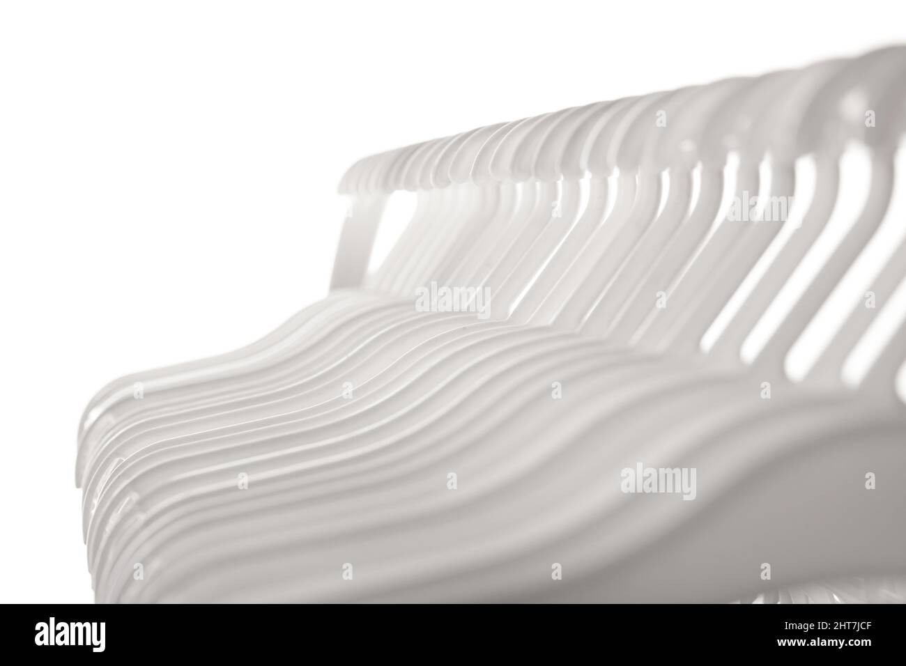Abstract white plastic hangers for clothes hanging on rod from clothing ...