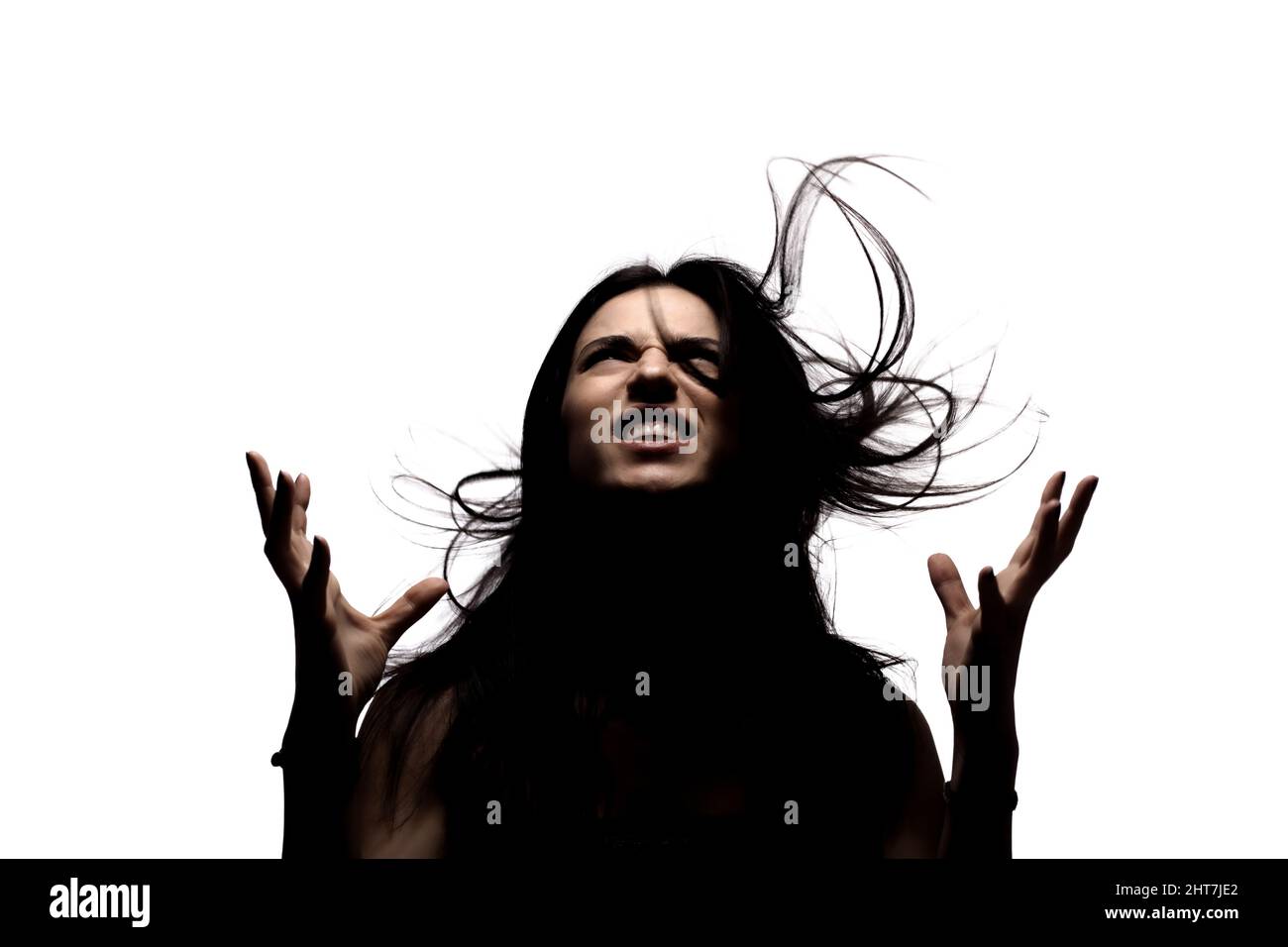 Dark portrait with shadows of an angry girl with hair in the air ...