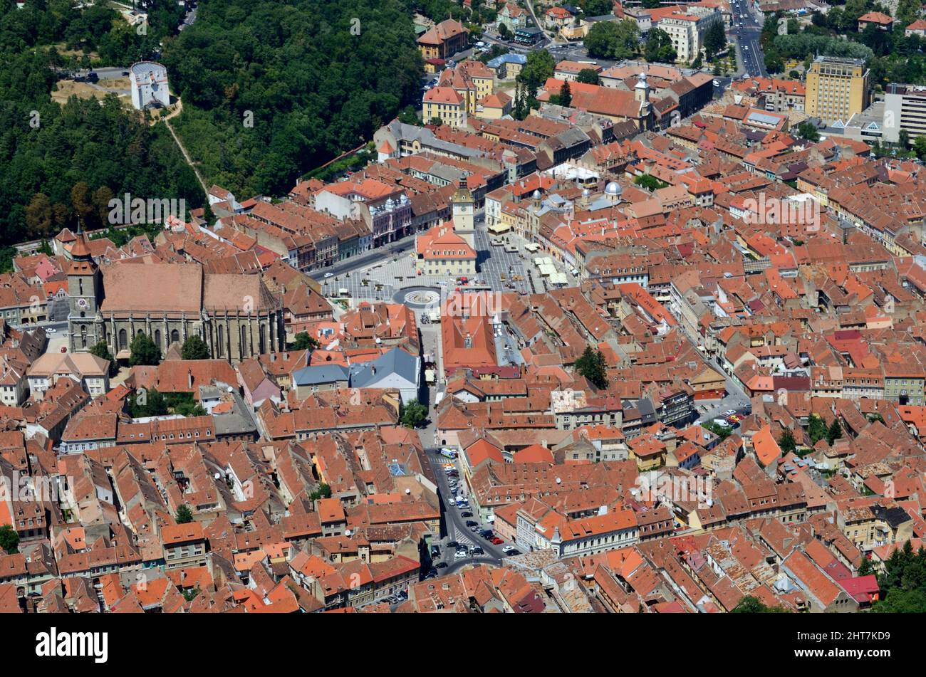 Aerial view of the city of Brasov with red roof buildings and trees ...