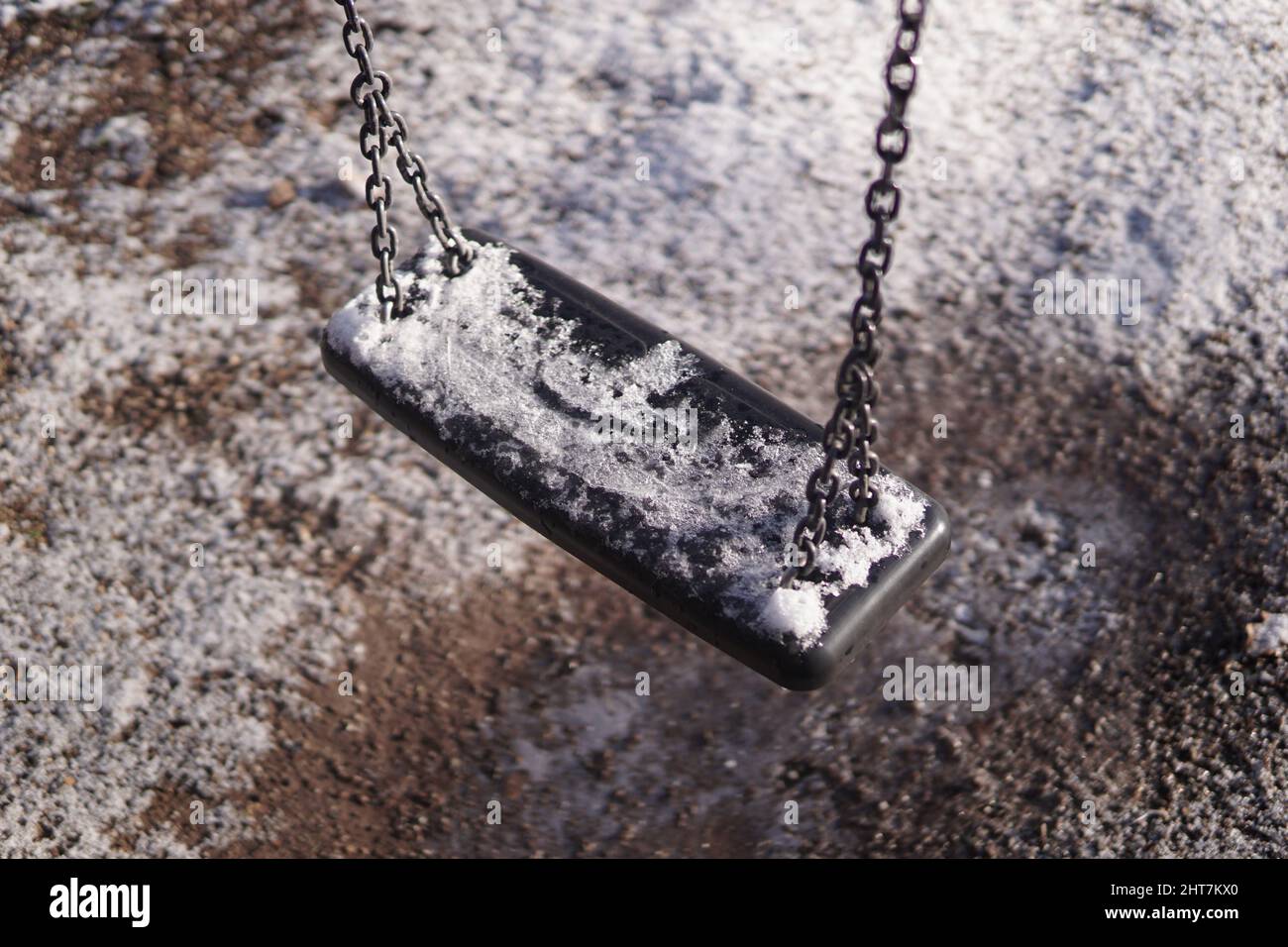 Snowy swing in a playground Stock Photo - Alamy