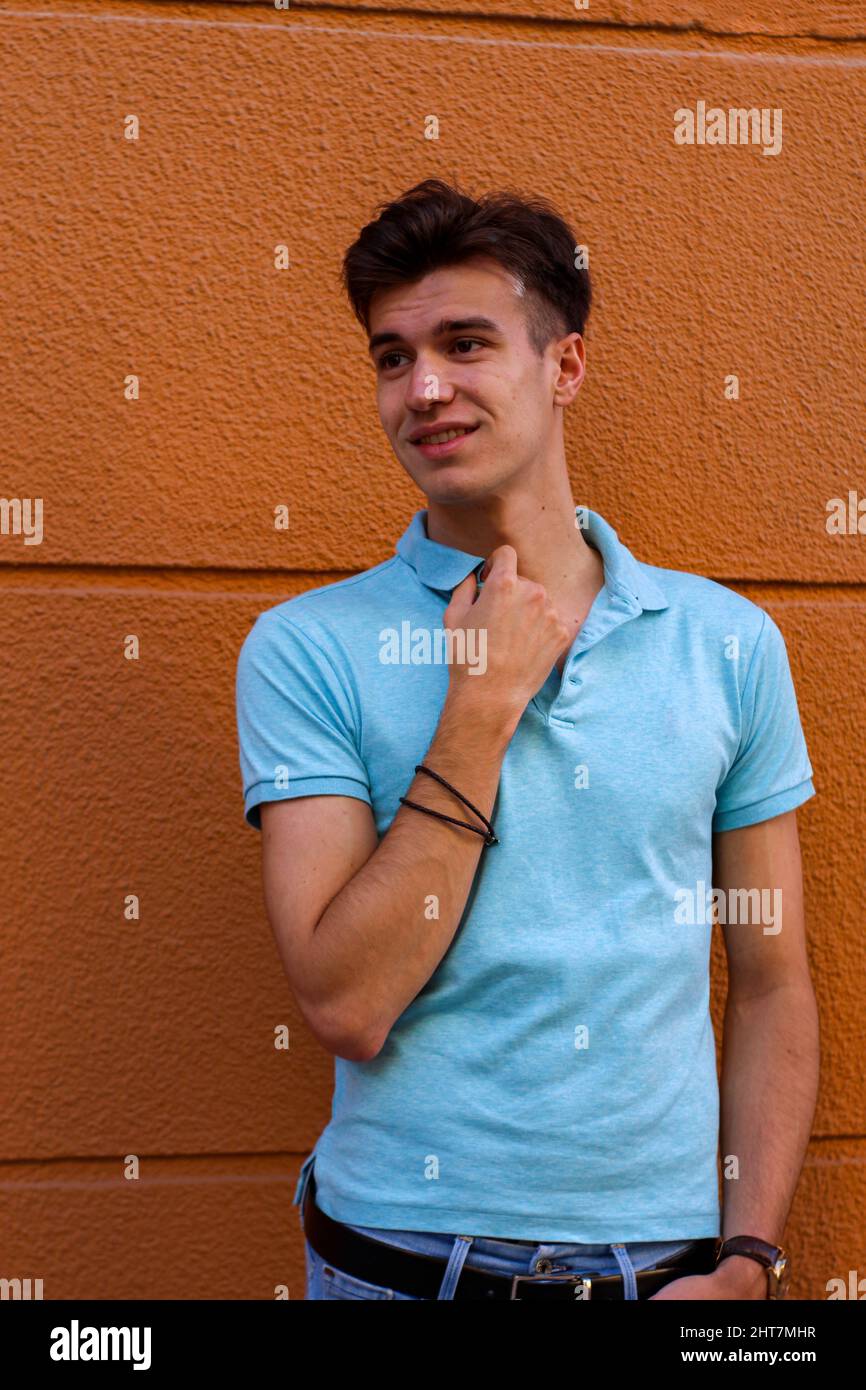 Vertical shot of a young attractive male in a blue collared shirt ...