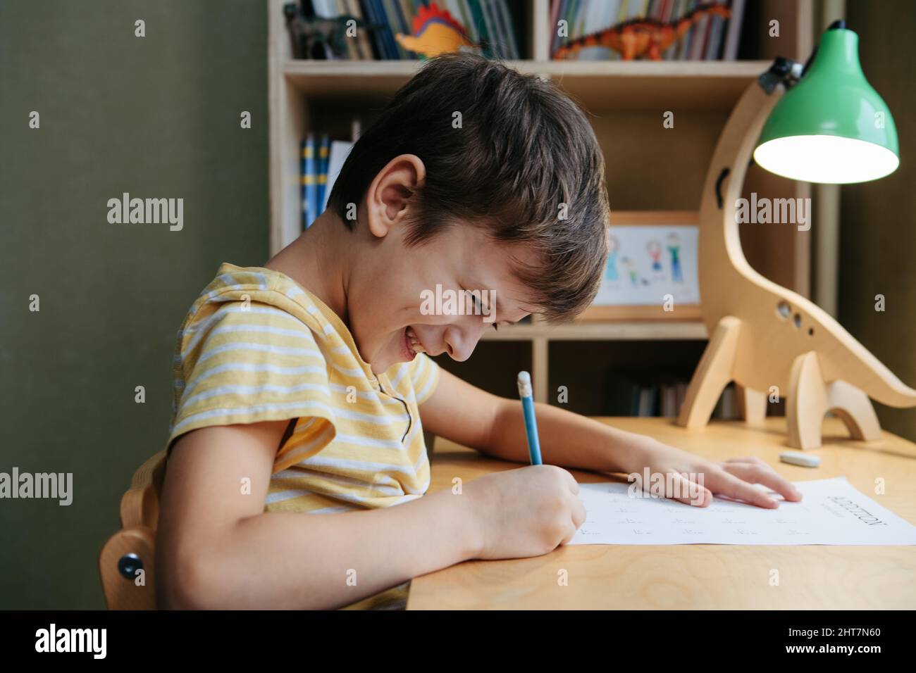 A schoolboy doing math lesson sitting at desk in the children room ...
