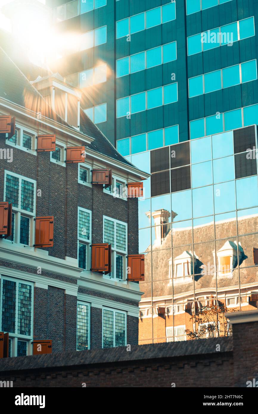 Vertical shot of a vintage stone building near a modern glass building ...