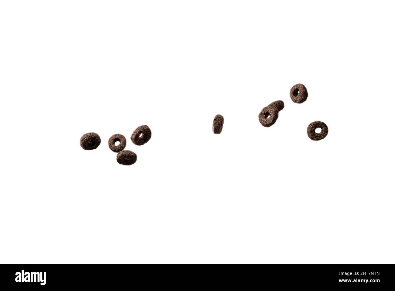 Chocolate rings cereal spill out into a bowl. Breakfast. Isolated on a ...