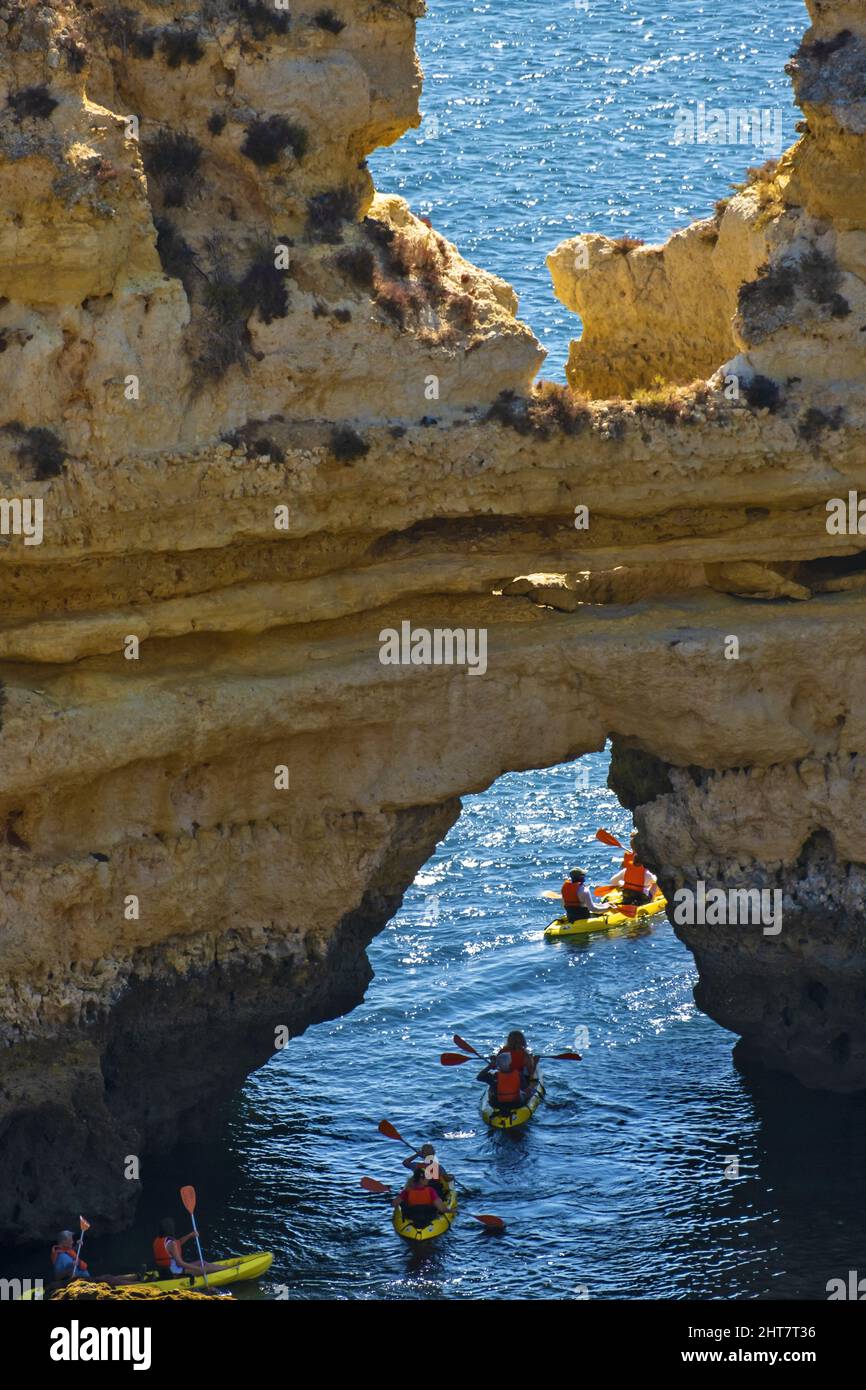 kayaking around rocky arch on beach Praia do Camilo in Lagos, Algarve ...