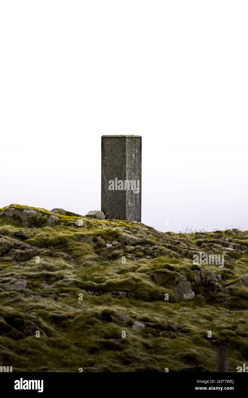 View of a vertical stone structure rising upwards from mossy rocks in ...
