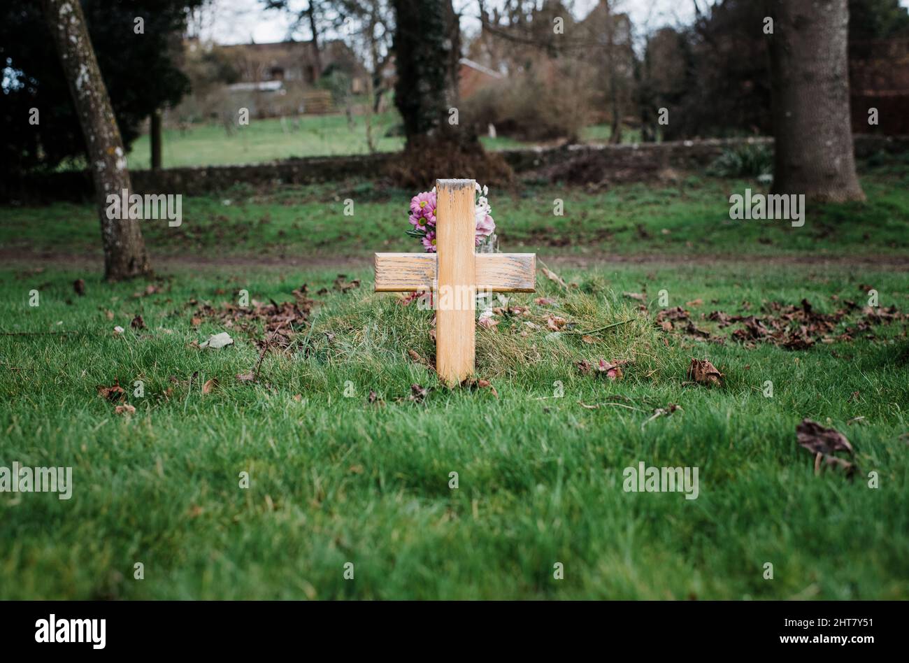 wooden cross at a graveyard cemetary with flowers Stock Photo - Alamy