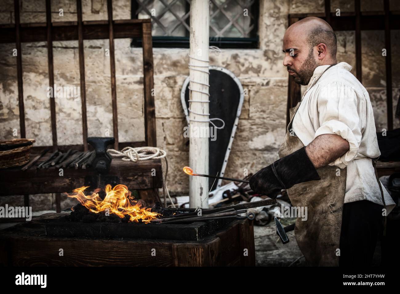 A Sword smith shaping a blade on an anvil Stock Photo - Alamy