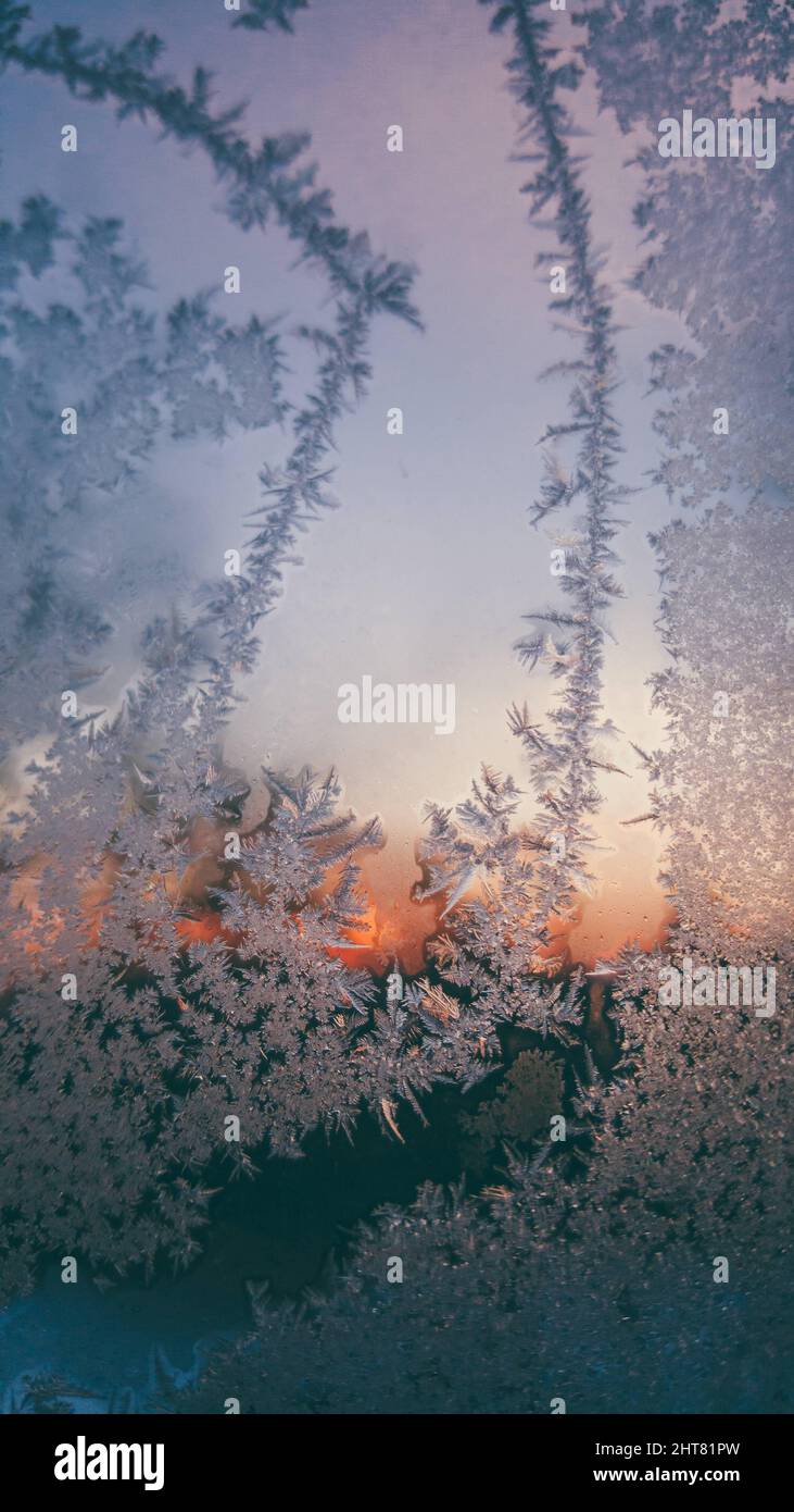 Vertical background of a frozen window with beautiful snowflake ...