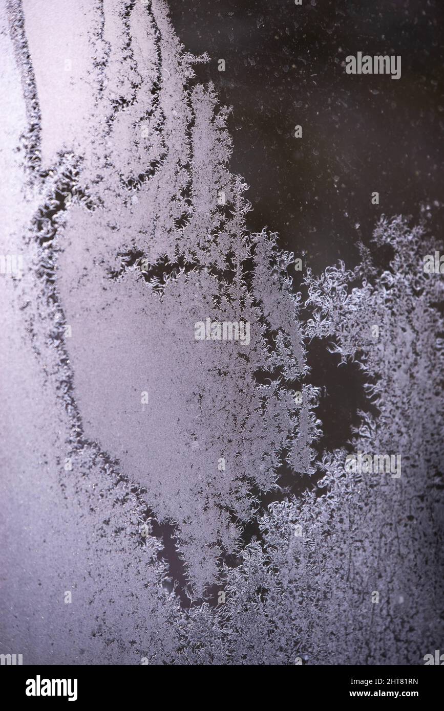 Vertical background of a frozen window with beautiful snowflake ...