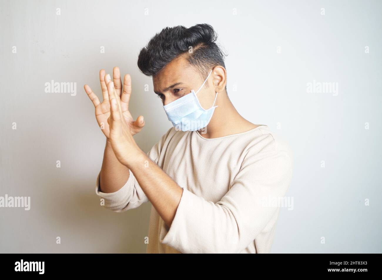 Young man holding his hands up, wearing a surgical mask Stock Photo - Alamy