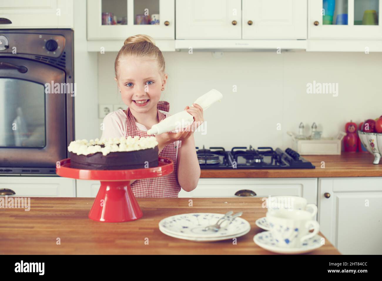 I made this cake all by myself. Cute little girl icing a cake in the ...