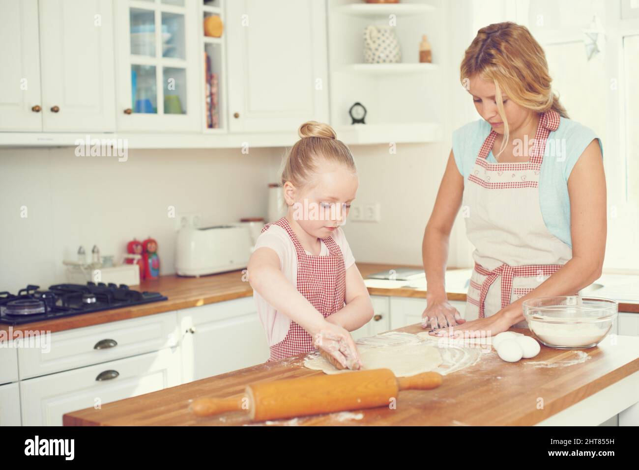 Doing some bonding over baking. Cute little girl baking in the kitchen ...