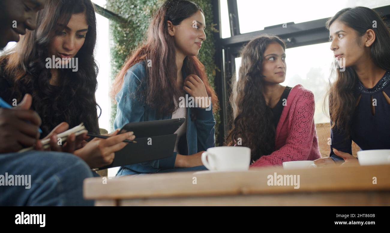 Group of young happy smiling students gathered and studying together ...