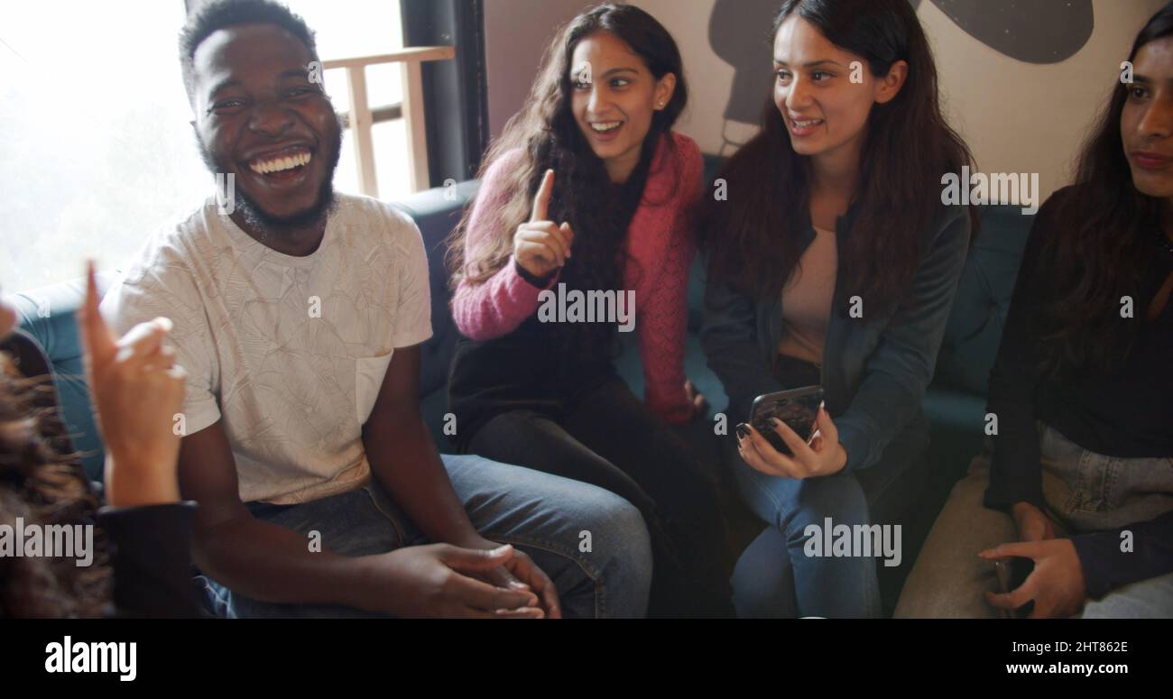 Group of young happy smiling friends gathered and having a good time ...