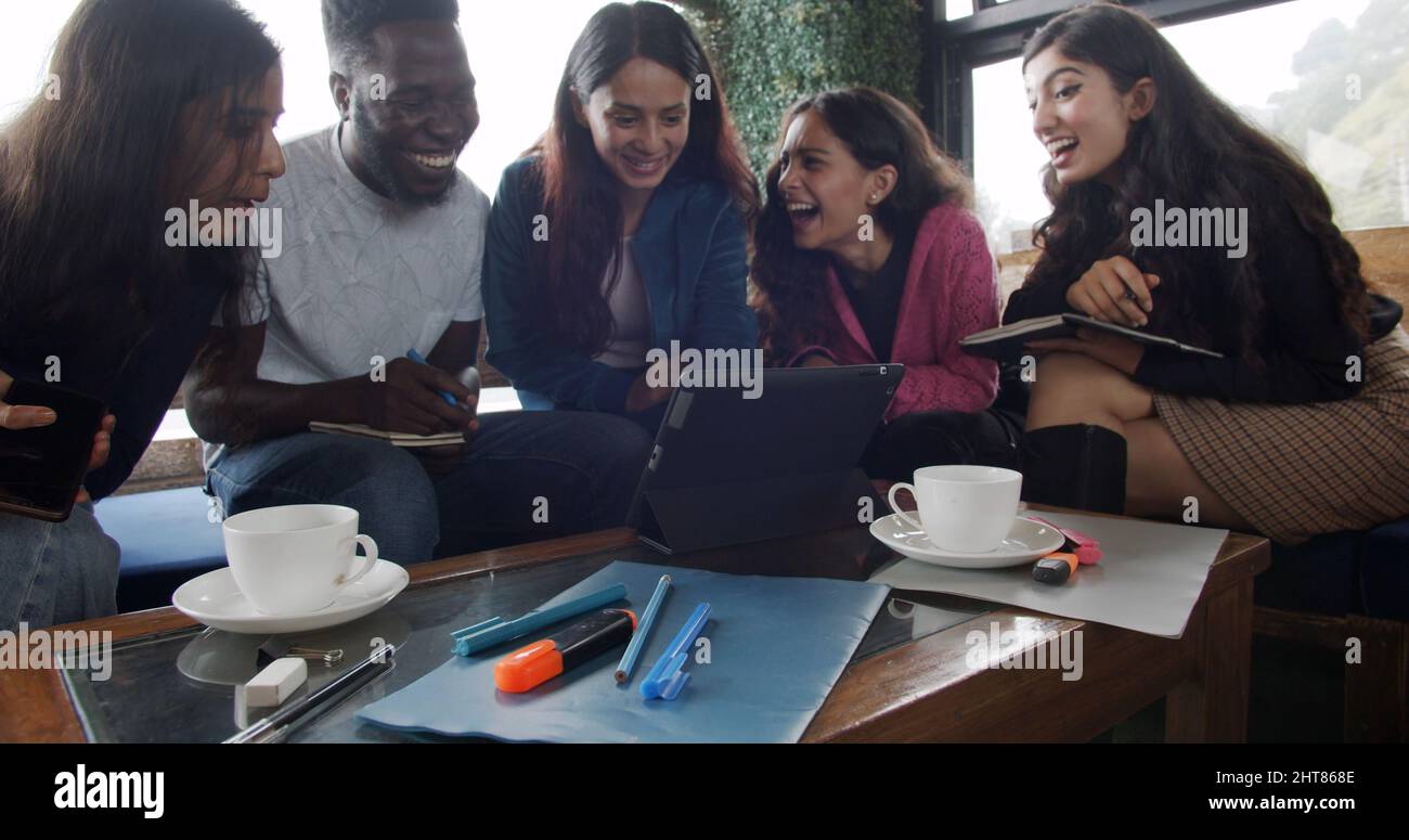 Group of young happy smiling students gathered and studying together ...