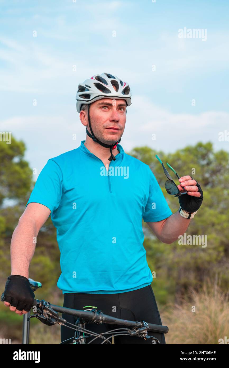 Vertical shot of a male biker taking a break after a bike ride Stock ...