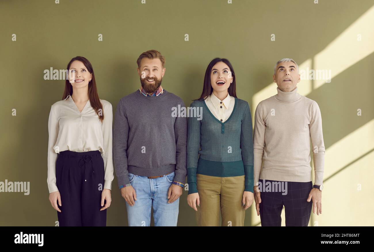 Portrait of smiling four surprised and amazed business people standing ...