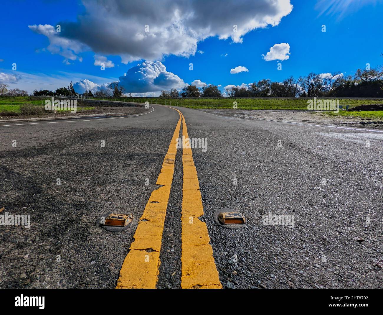 Low angle shot of yellows lines on a road under a bright sky Stock ...